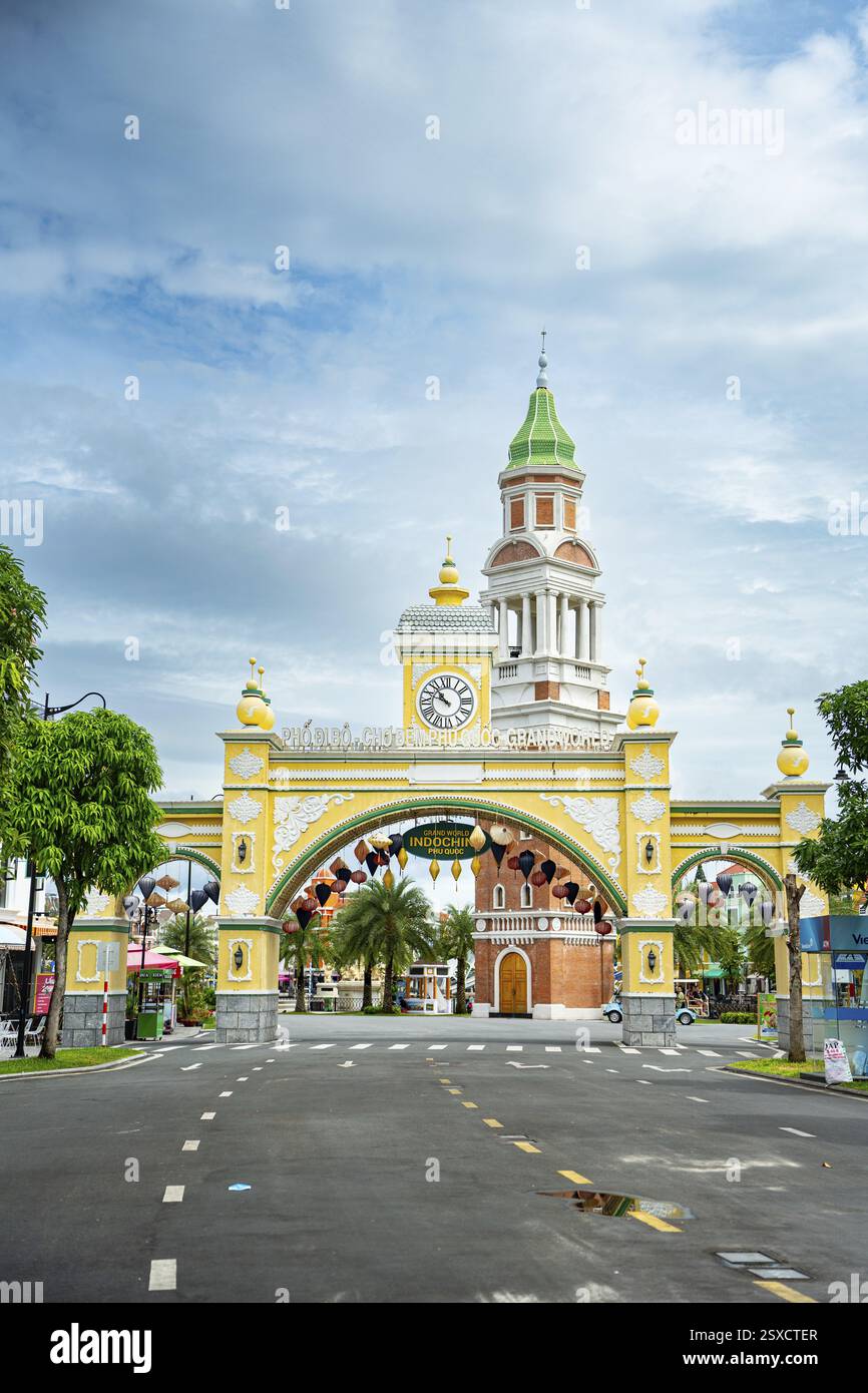 A grand entrance gate with clock and tower, leading to an empty road ...