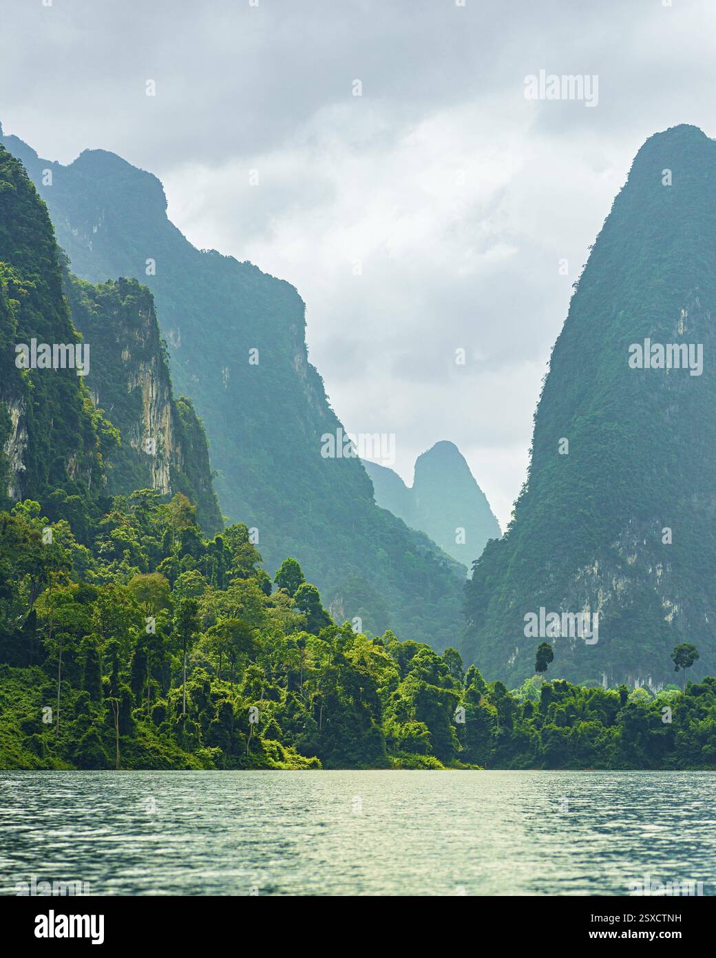 Towering mountain peaks enveloped in a mist create a serene atmosphere ...