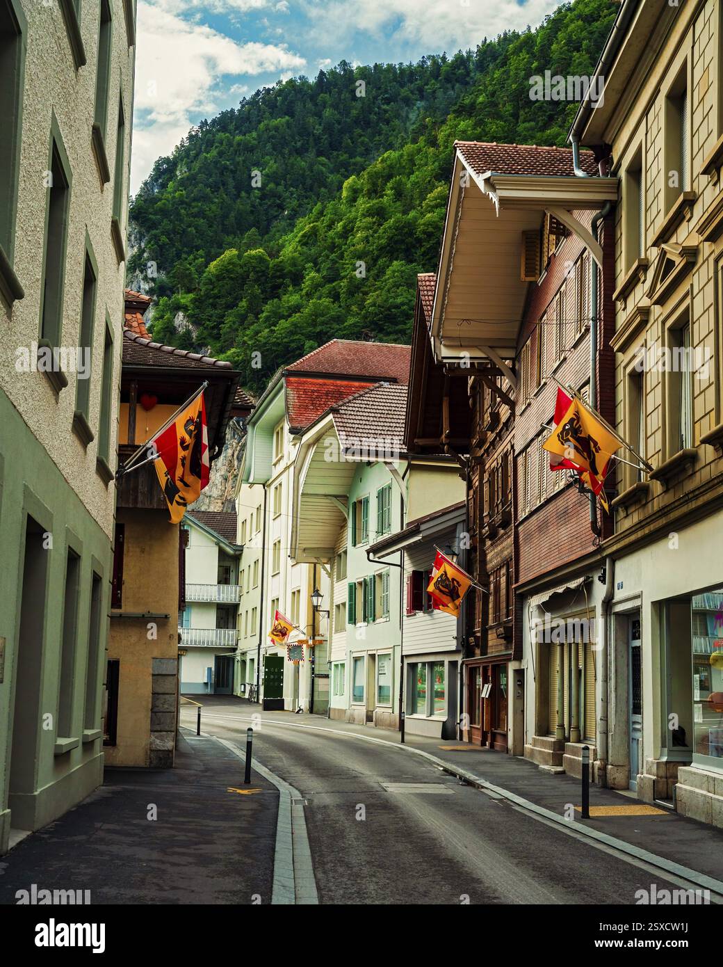 A peaceful narrow street with traditional buildings, flags, and a ...