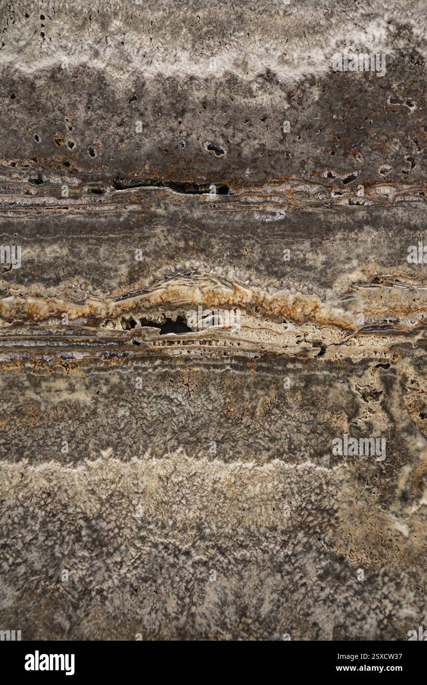 Stone surface with brown and gray layered striations showing natural ...