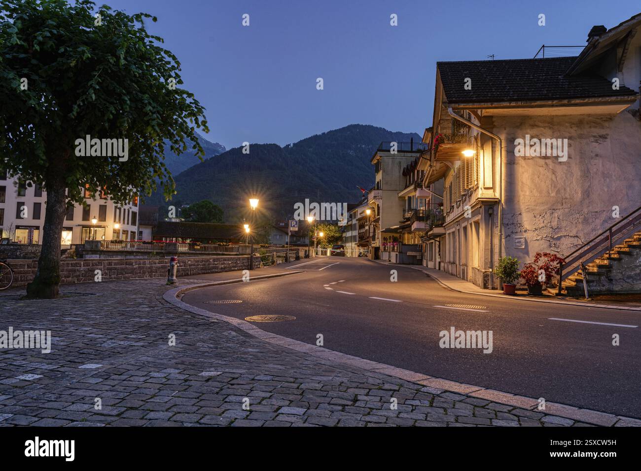 Calm nighttime street with warm lighting and empty surroundings, city ...