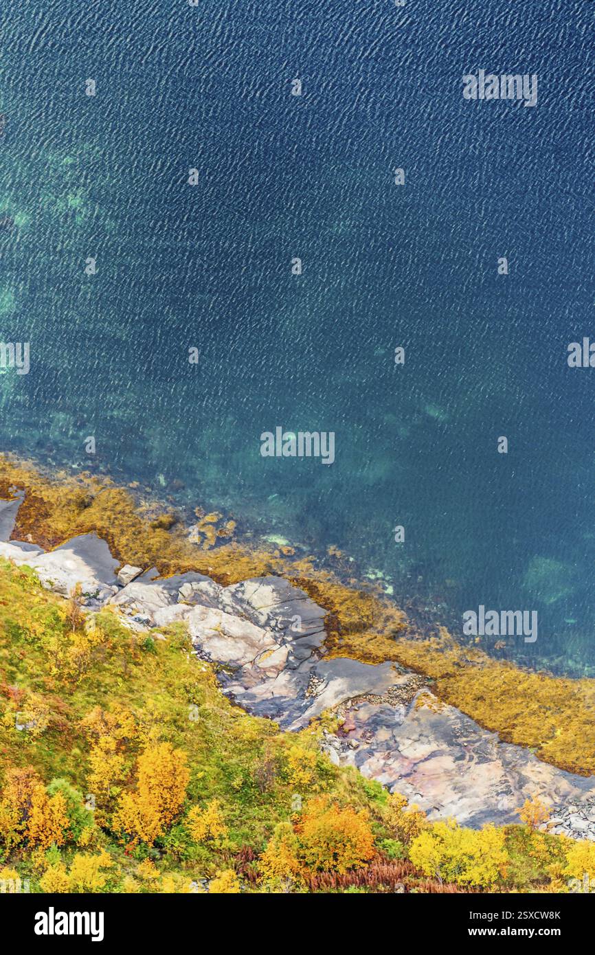 Aerial overview of rocky shorelines with autumn foliage and blue ocean ...