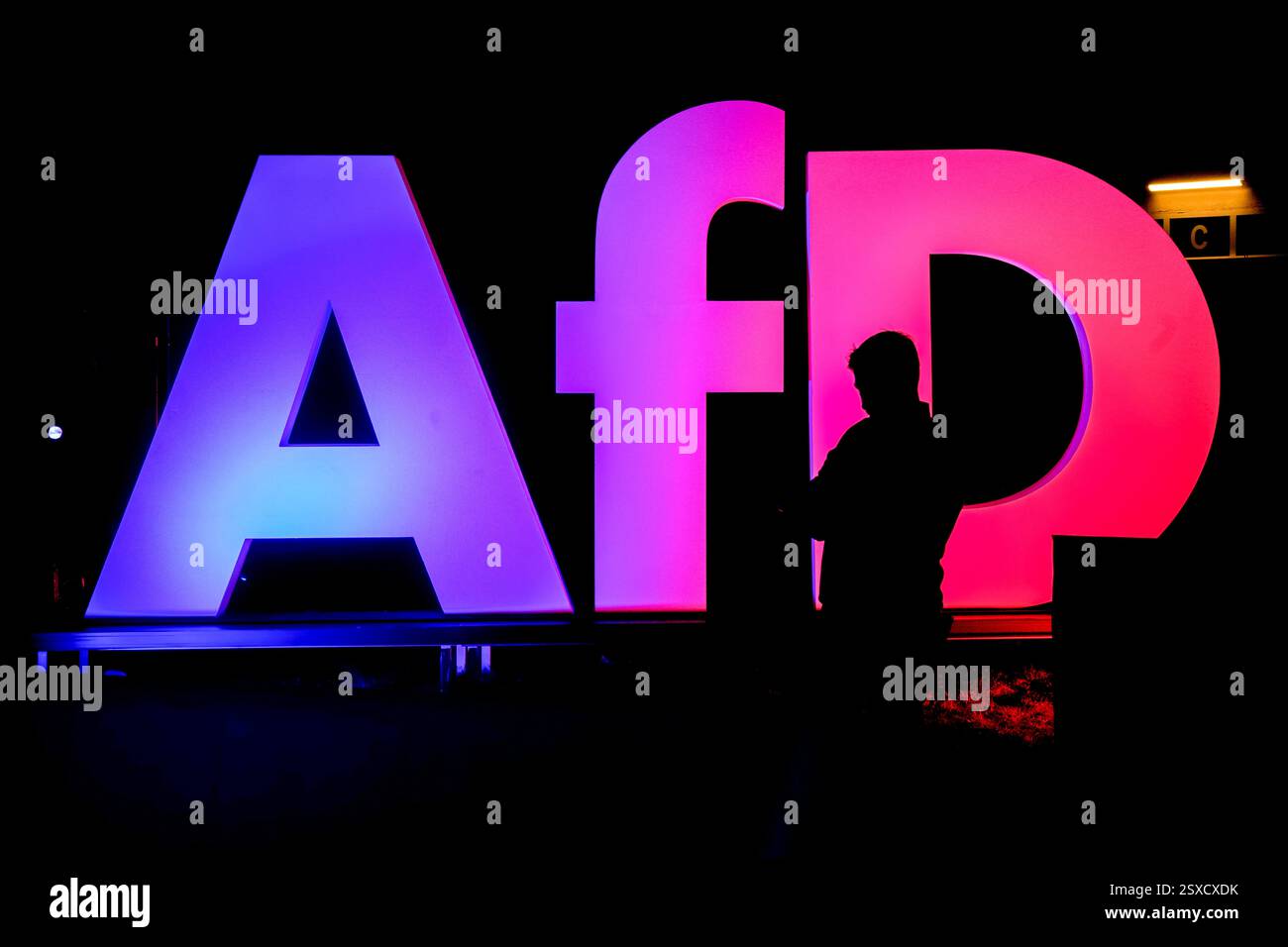 A man stands in front of the logo at the AfD party headquarters in ...