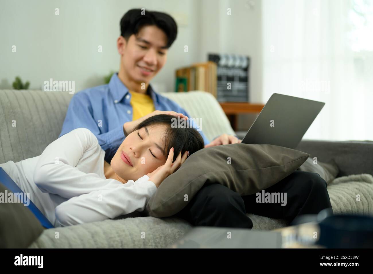 Peaceful woman taking a nap on couch with her head on her husband lap ...