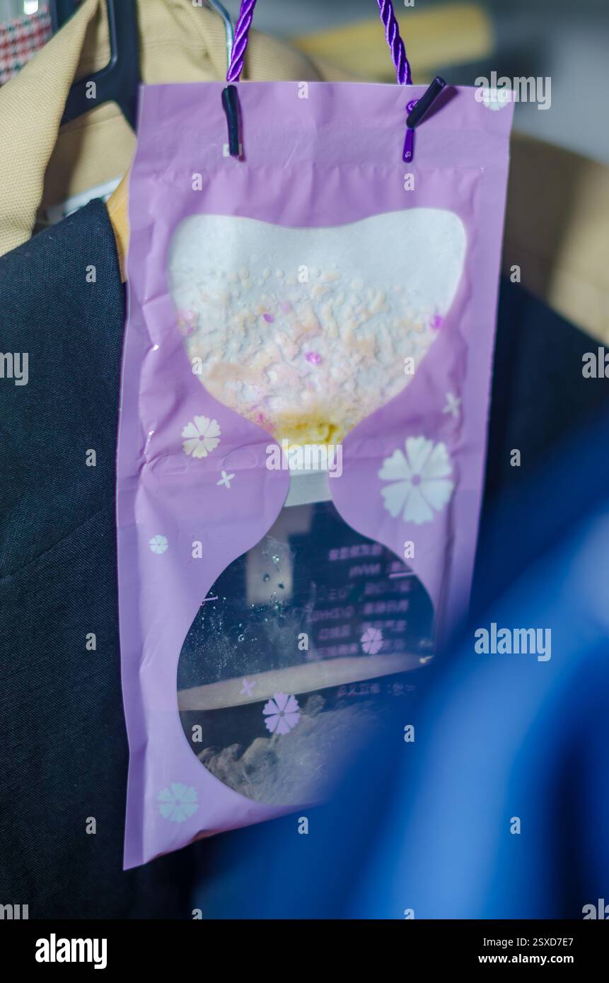 Purple hanging moisture absorber bag collecting humidity in a closet ...