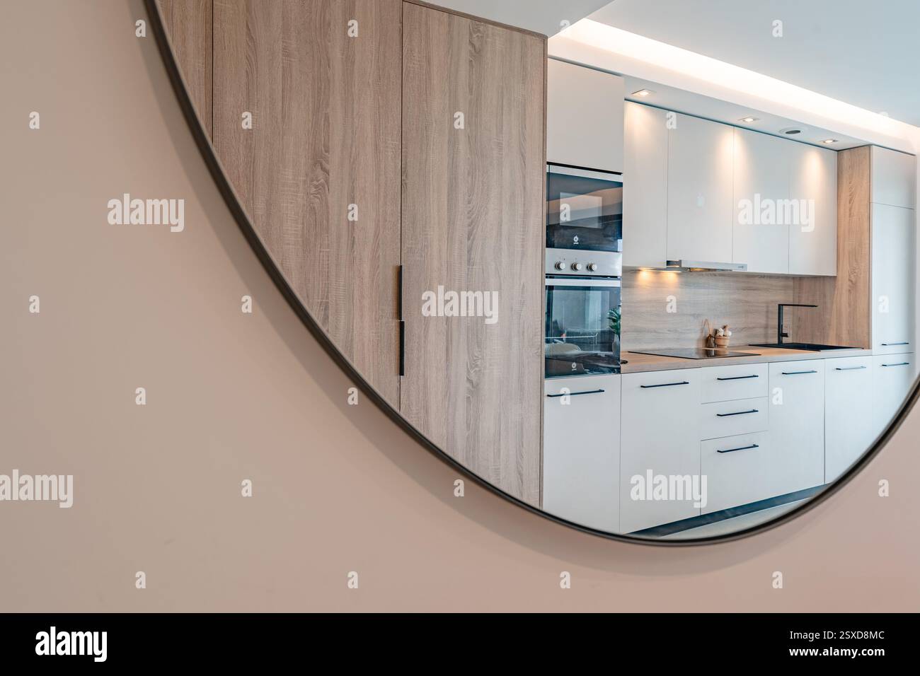 a reflection in a round mirror of an illuminated mediterranean kitchen ...