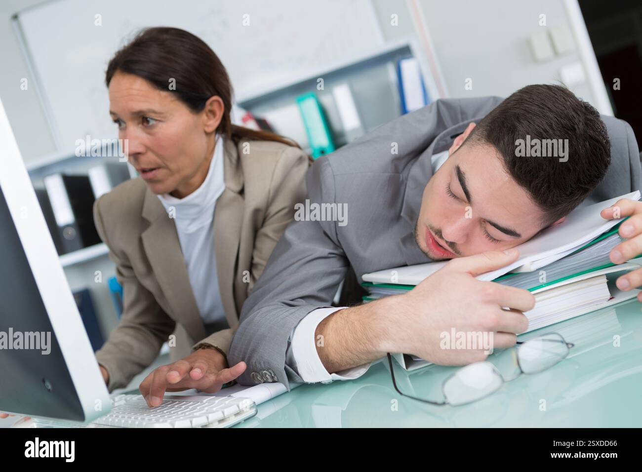 female manager next to a sleeping office worker Stock Photo - Alamy