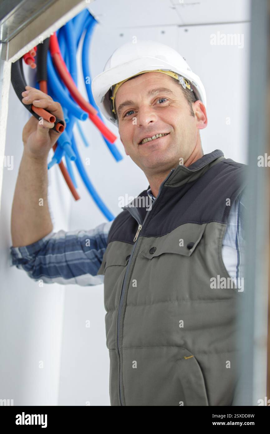 male tradesman holding bundle of water pipes Stock Photo - Alamy