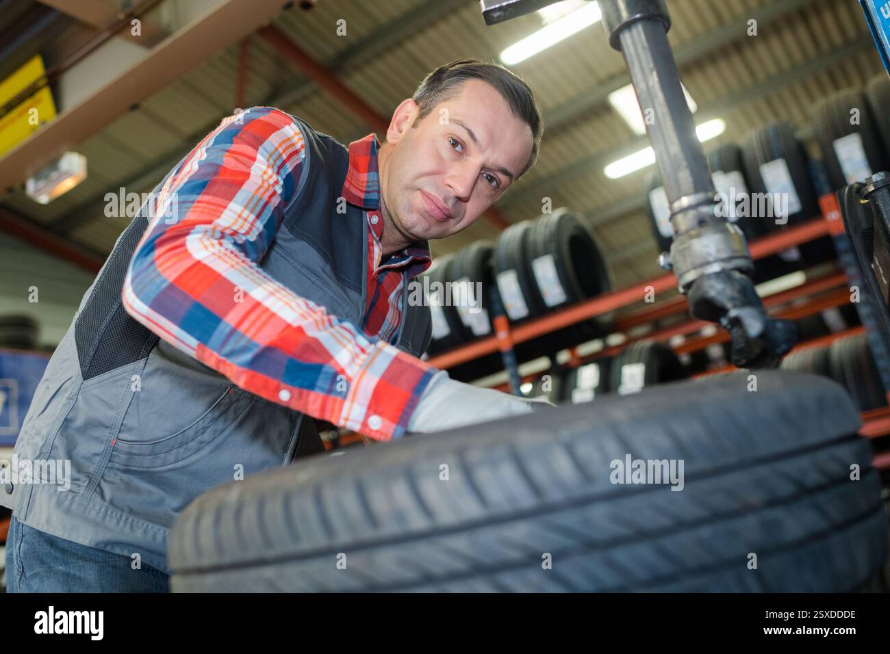 Worker checking tires in garage hi-res stock photography and images - Alamy