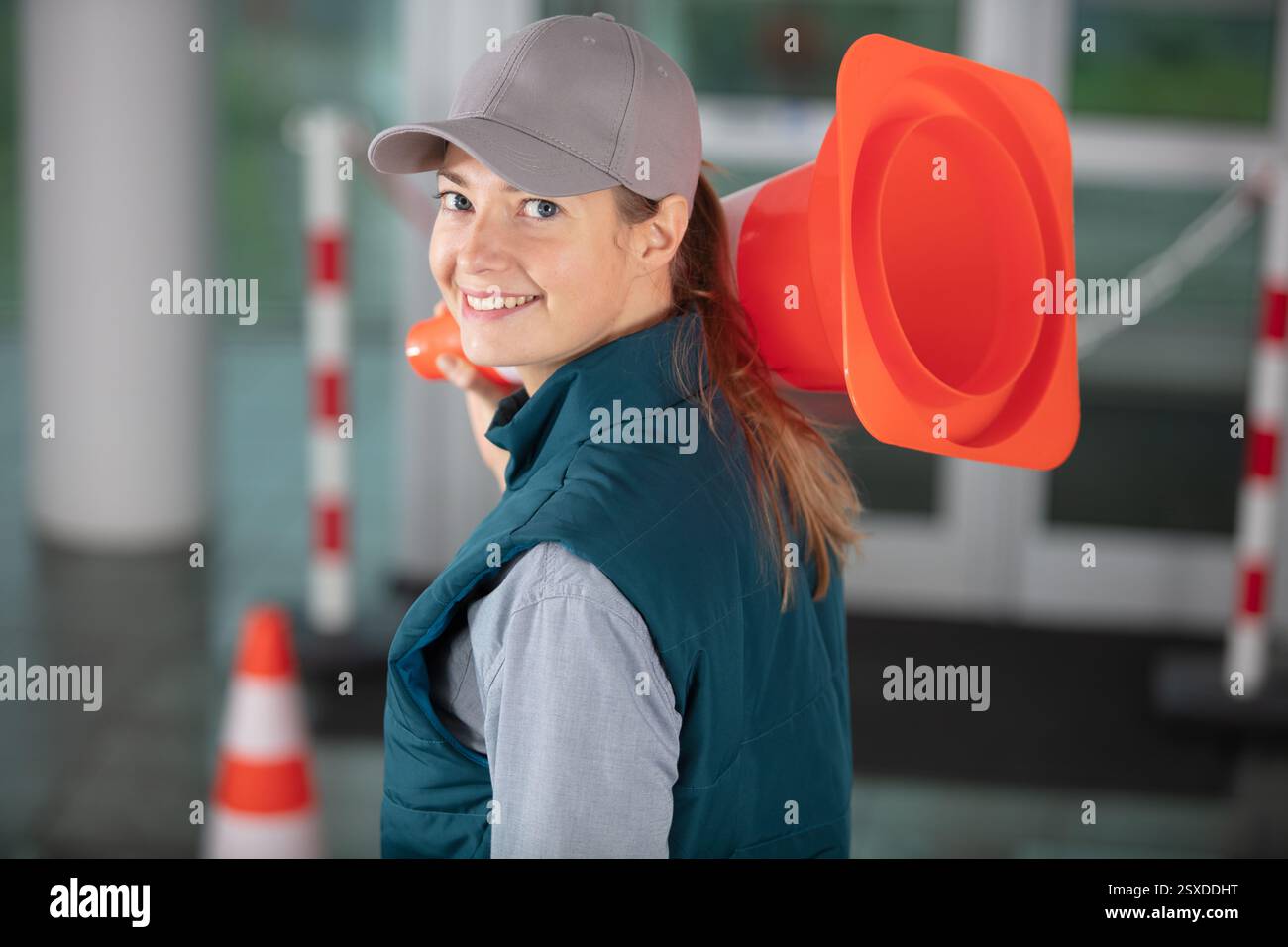 happy female builder holding traffic cone Stock Photo - Alamy