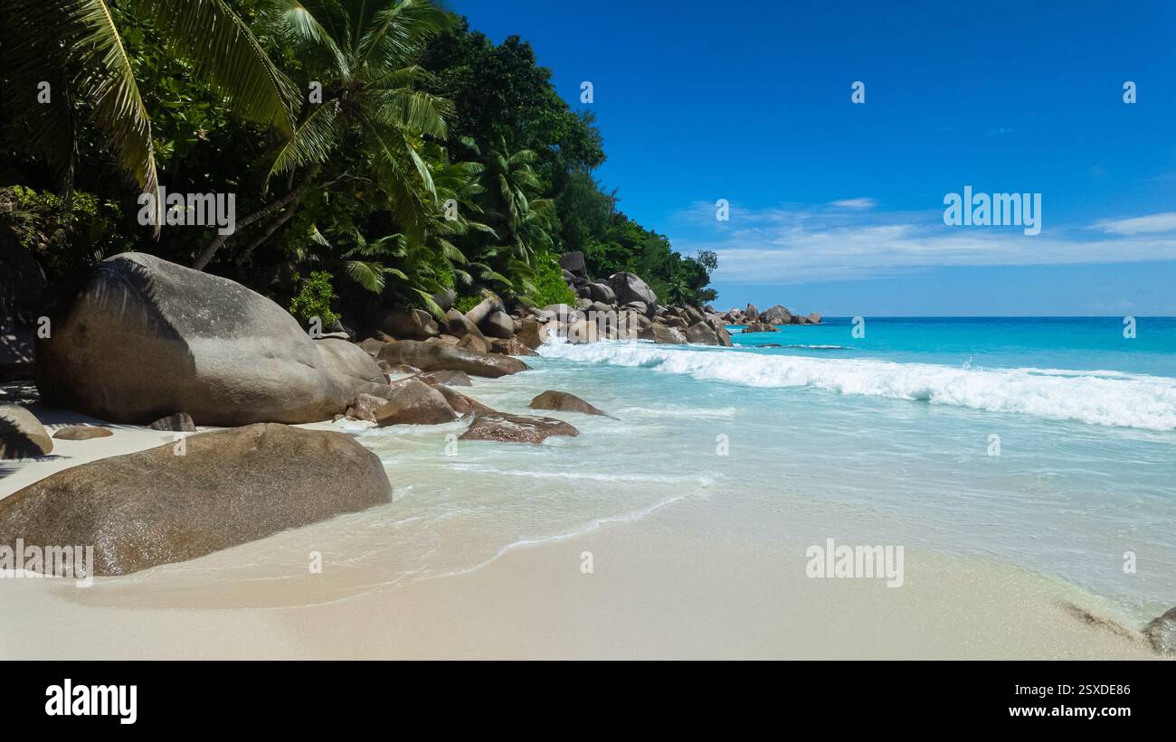Idyllic beach with turquoise water, granite rocks, and lush tropical ...
