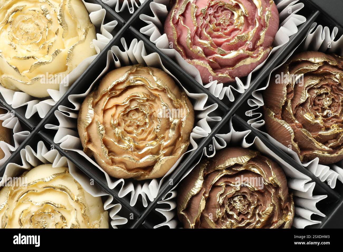 Flower shaped chocolate bonbons in box, top view Stock Photo - Alamy