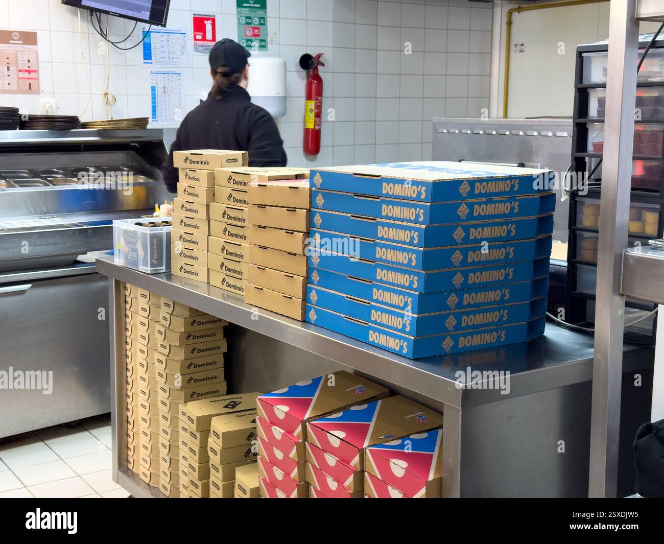 Busy pizza kitchen with stacks of boxes preparing for delivery rush ...