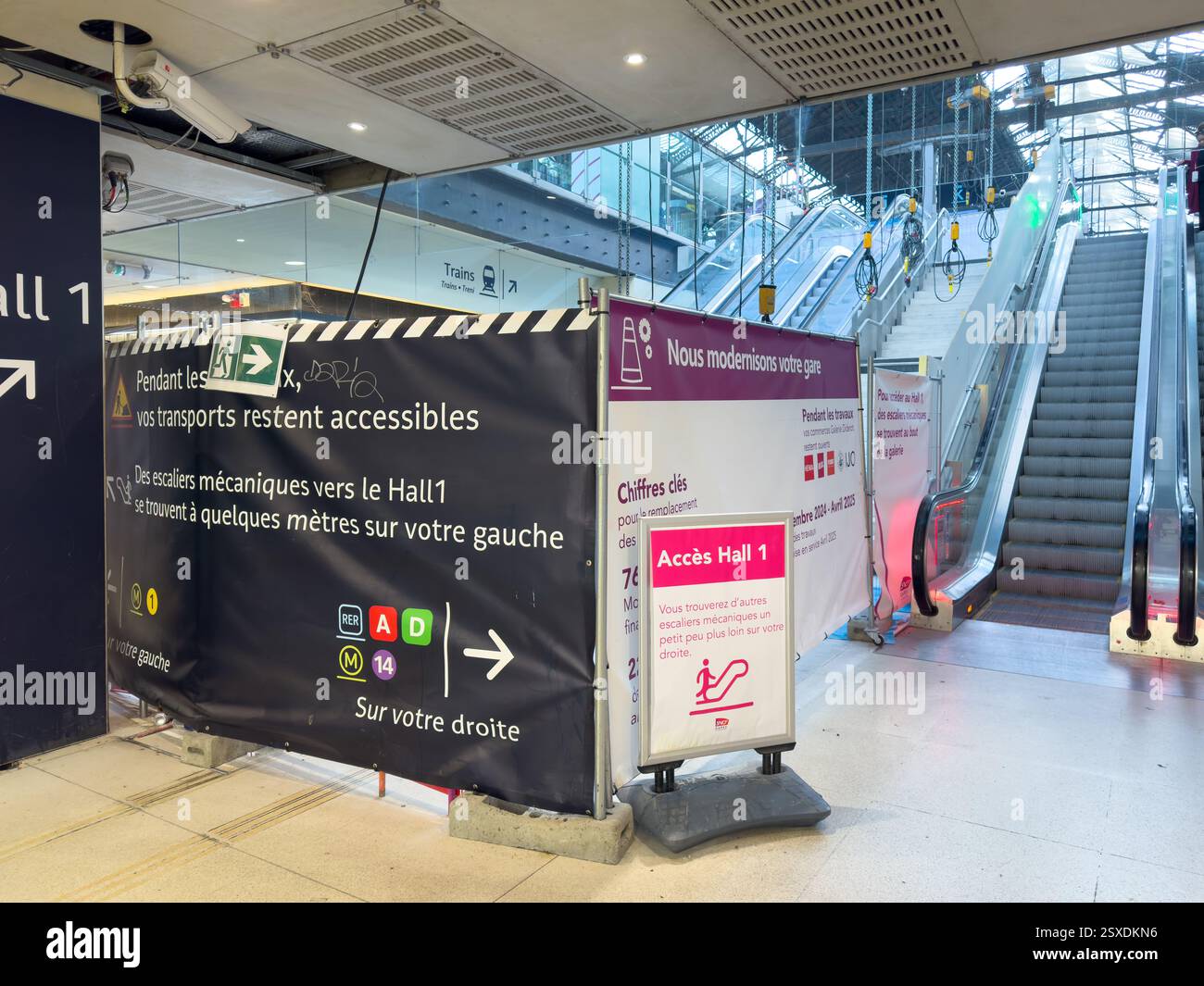 Signage guiding passengers at a busy train station during construction ...
