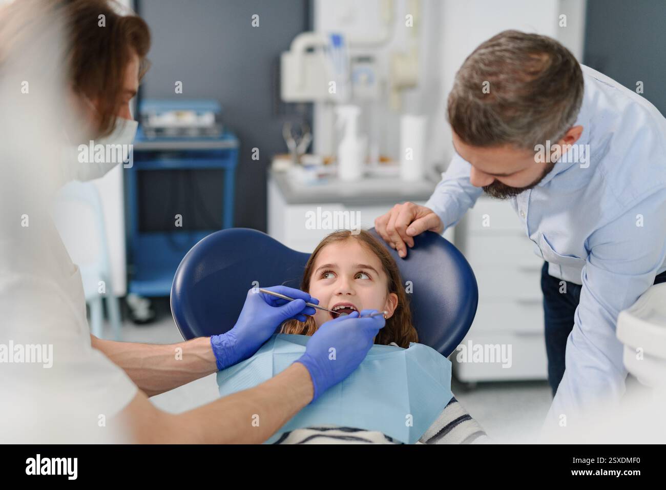 Cute girl during annual dental check-up in dental clinic, father supporting her Stock Photo - Alamy