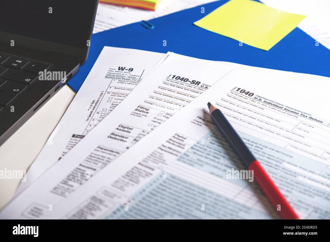 Tax form 1040, w-9, pencil, marker pen, reading glasses and laptop are ...