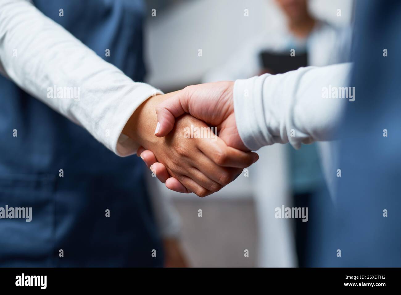 Close-Up of Handshake Between Medical Professionals Wearing Scrubs in a ...