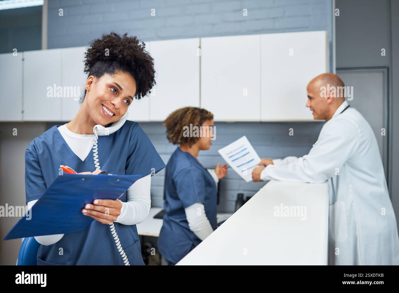 Medical Team Reviewing Documents and Assisting Patients in a Well ...
