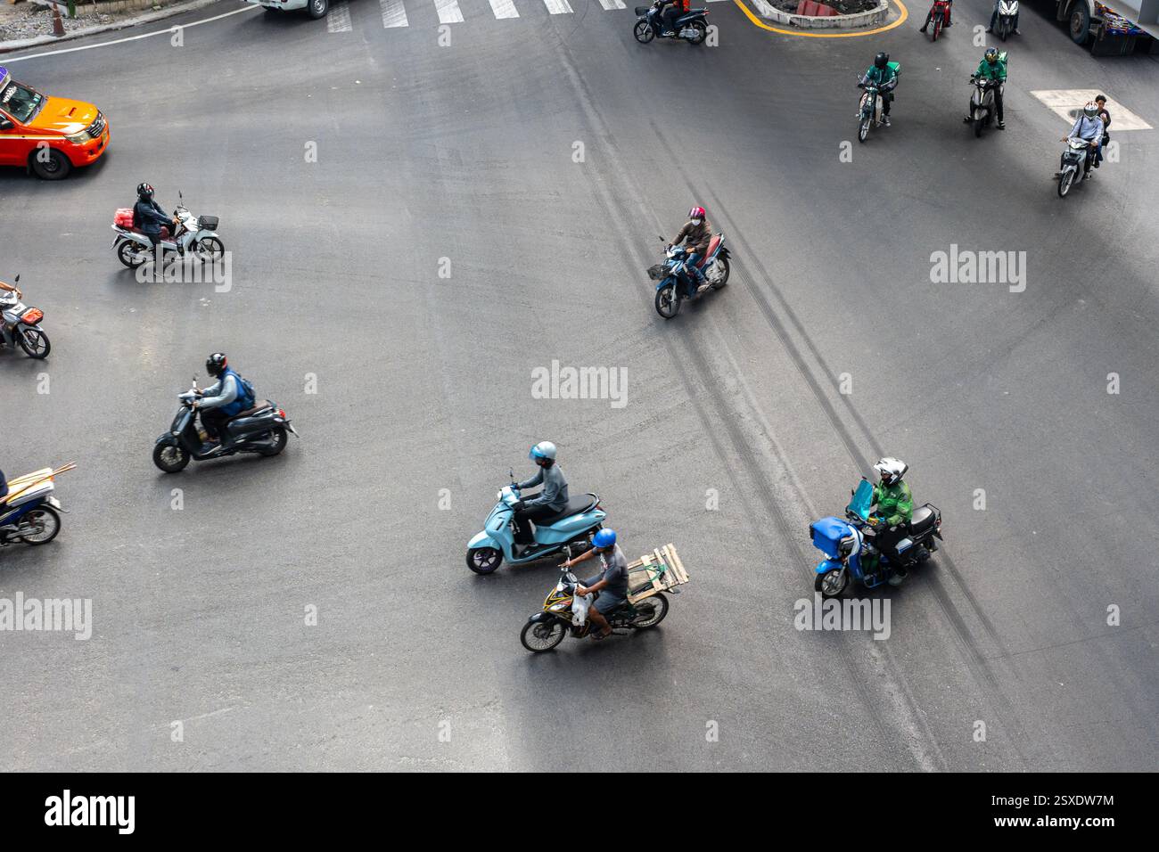 A close-up view of motorcycles crossing an intersection, with tire ...