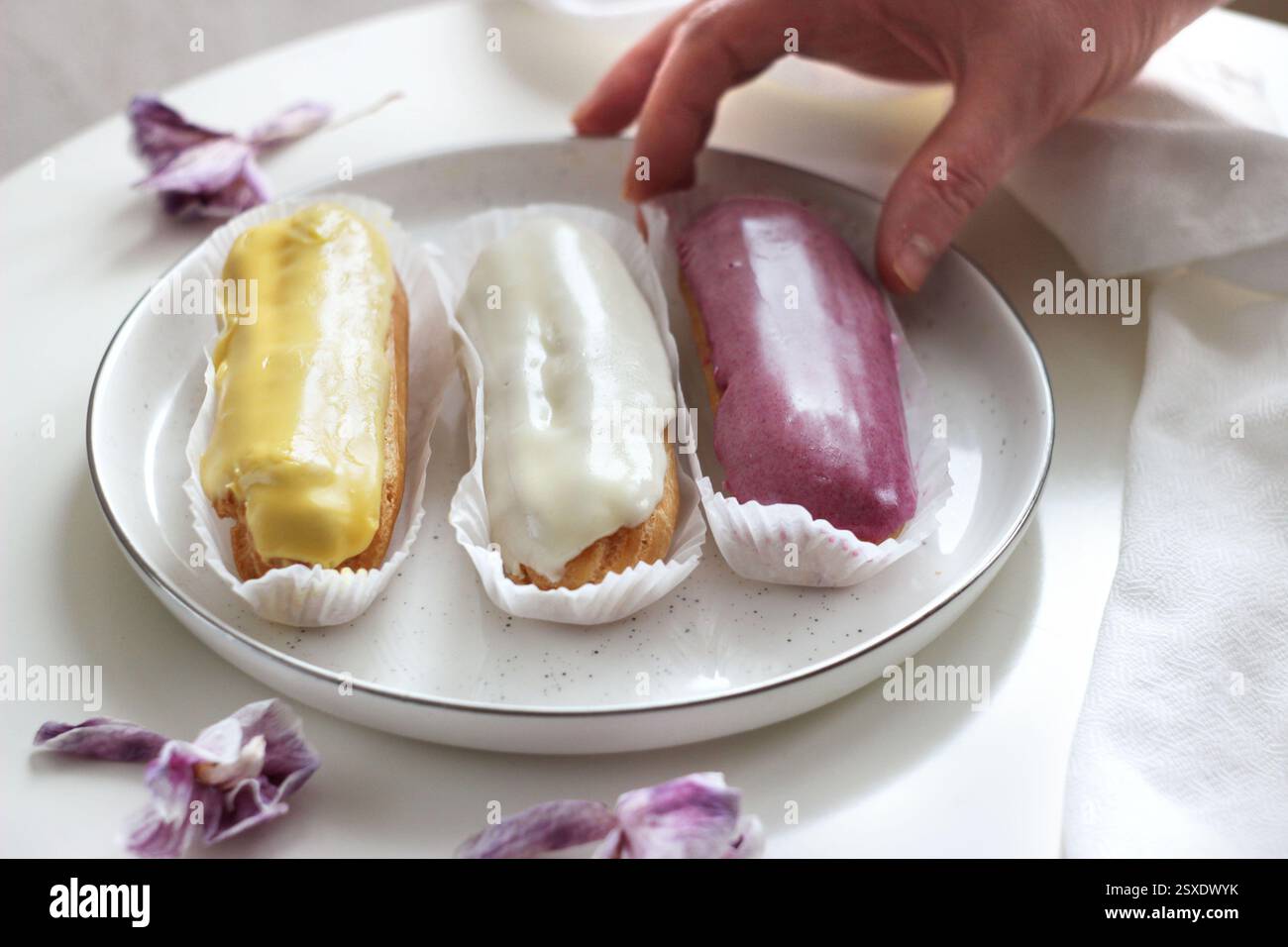 Three eclairs with different fillings lie in a plate Stock Photo - Alamy