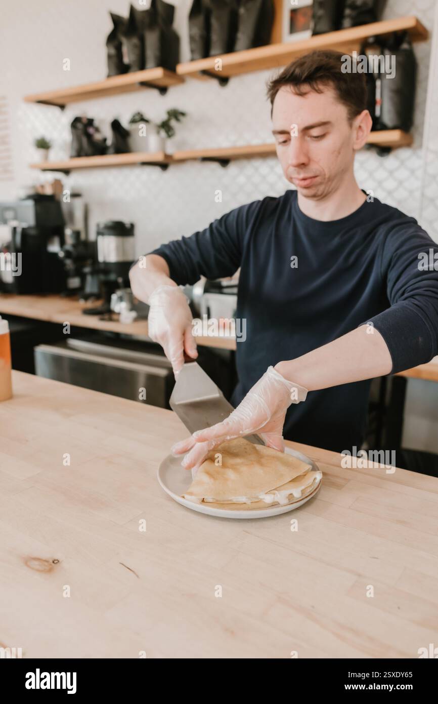 Barista serving a freshly made crepe on a wooden counter in cafe Stock ...
