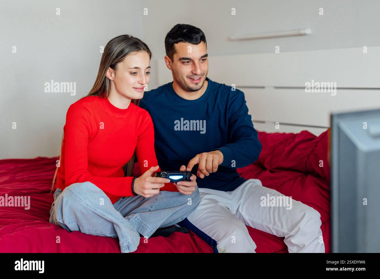 Young couple playing video games in bed using wireless controller Stock ...
