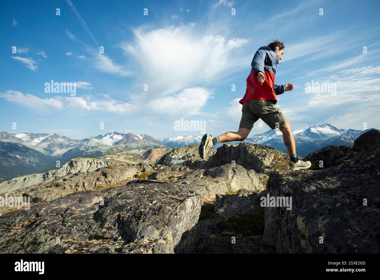 Trail runner moving over rugged terrain with glaciers in view Stock ...