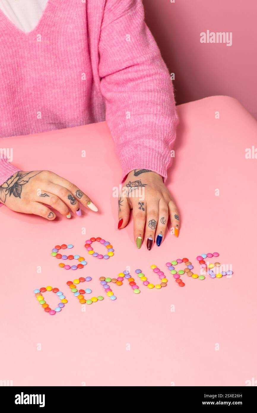 A playful composition with "SO DEMURE" spelled out in colorful candy on ...
