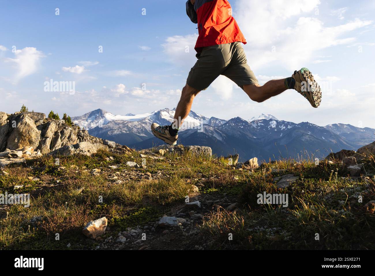 Trail runner moving over rugged terrain with glaciers in view Stock ...