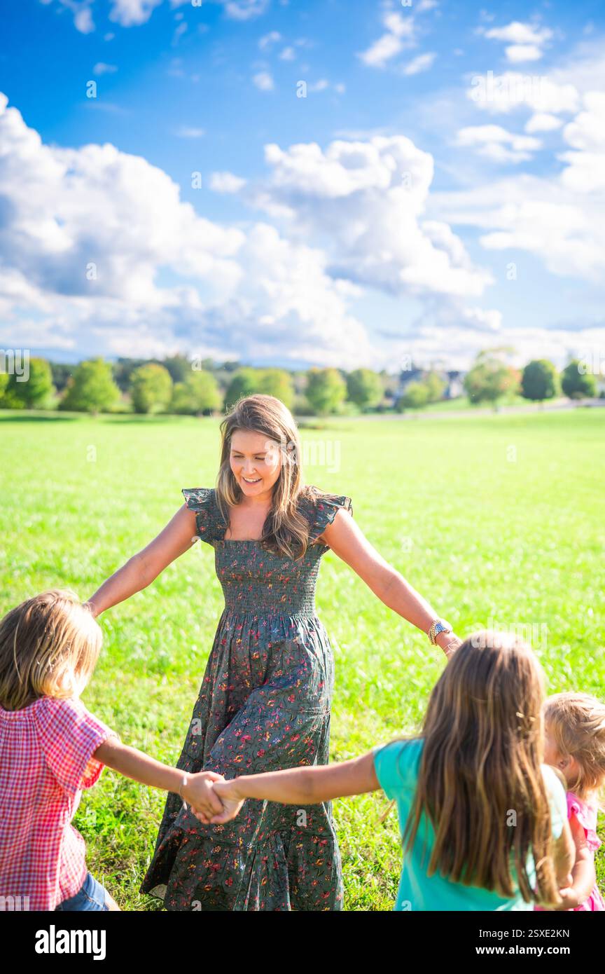 Mom and Daughters Playing Ring Around the Rosie in their Backyard Stock ...
