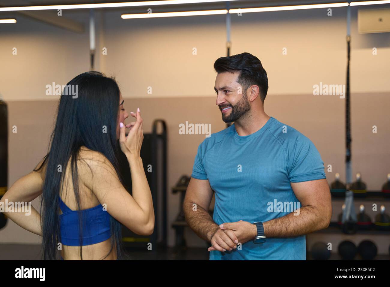 Fitness coach and client sharing a motivational moment in a modern gym ...