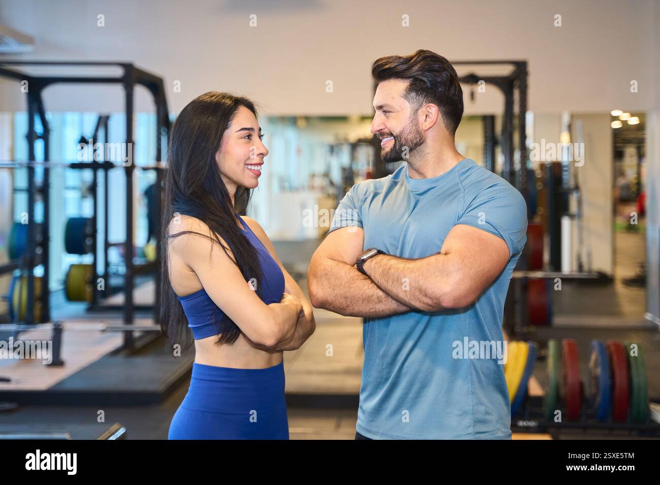 Fitness trainers share a friendly conversation in a gym setting ...