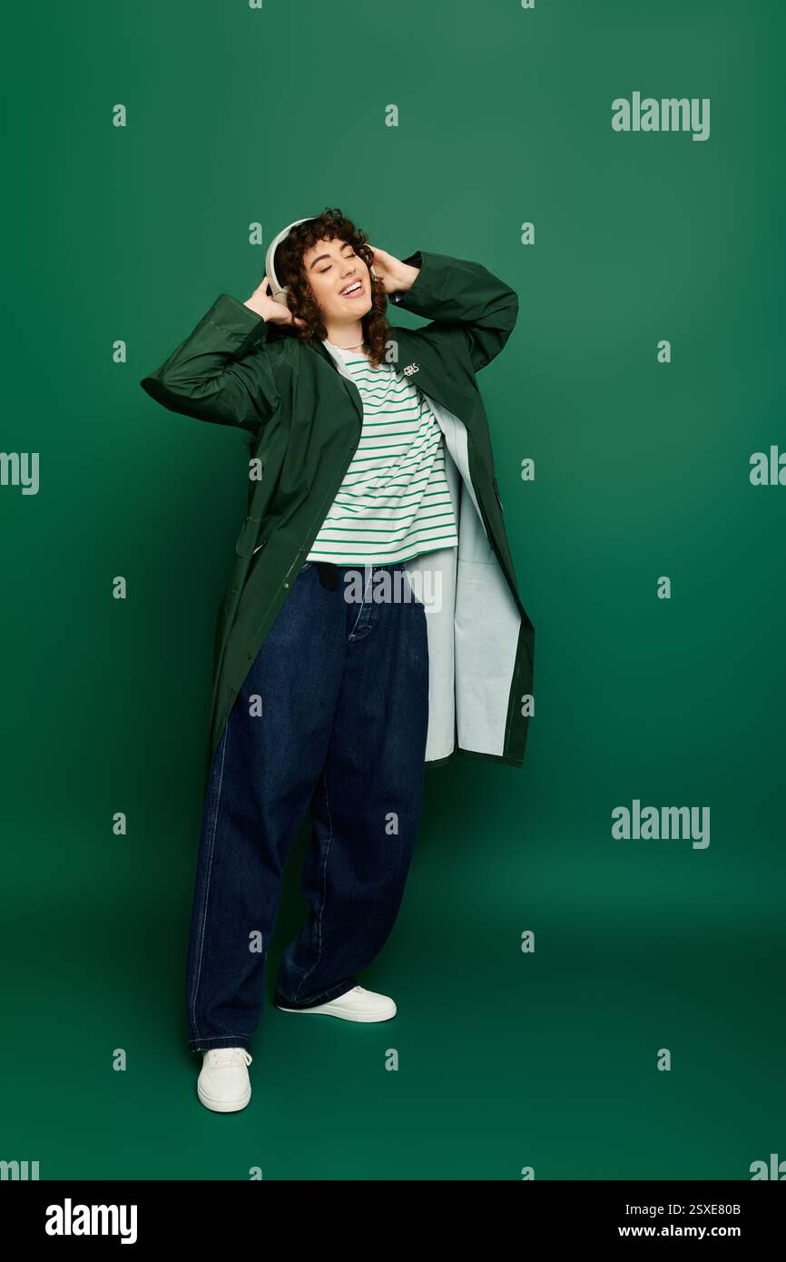 A beautiful woman celebrates happiness with a playful pose and trendy ...