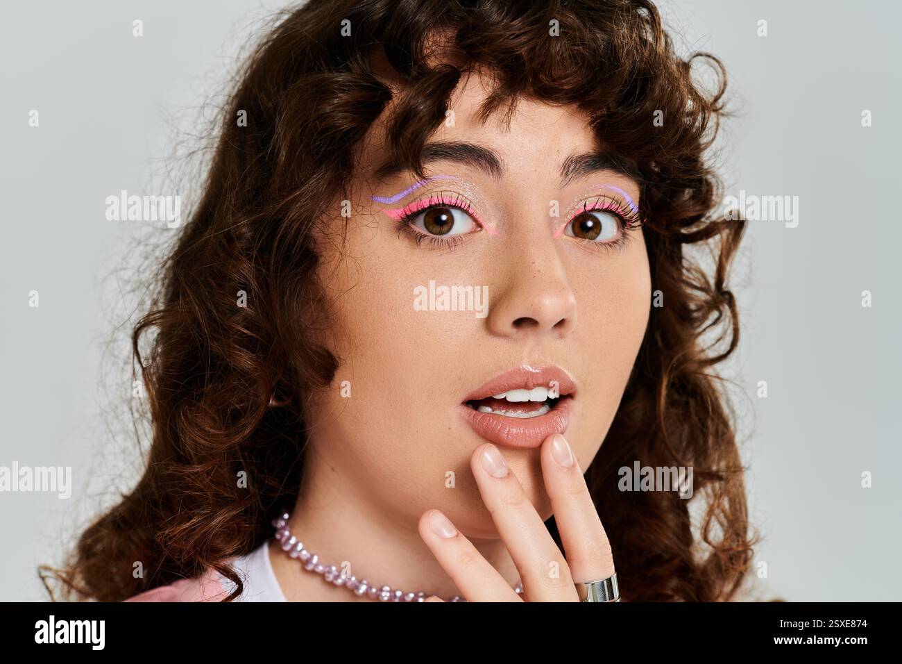 A stylish young woman expresses her emotions with colorful makeup in a ...