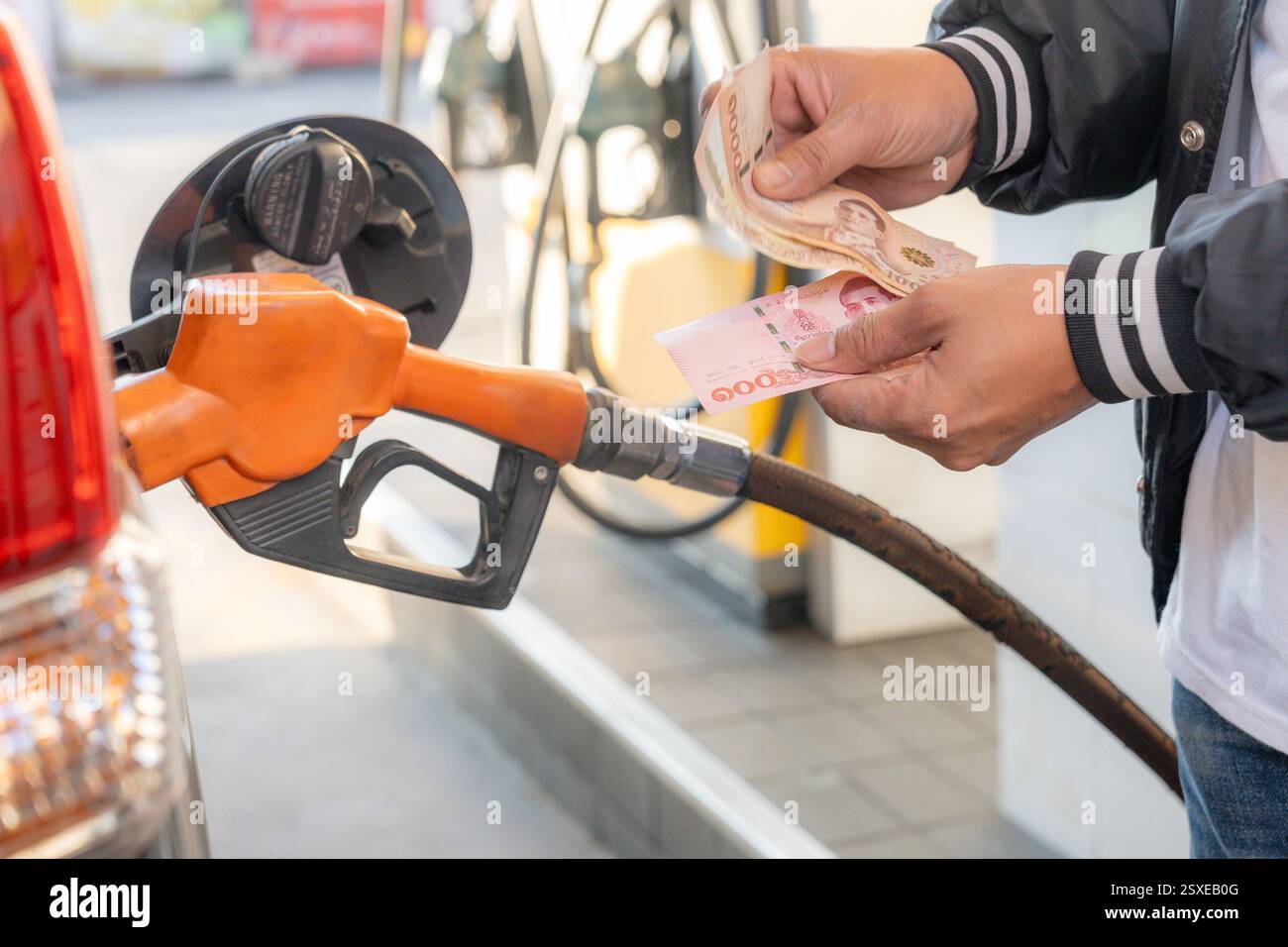 A man is paying for fuel with cash Stock Photo - Alamy