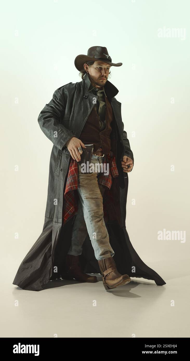 Portrait of sheriff, cowboy gripping revolver handle, wearing leather ...