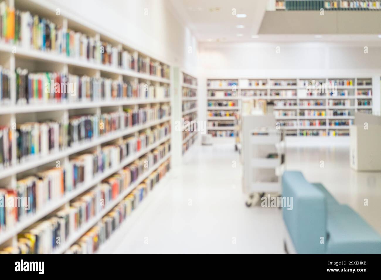 Library bookshelves stretching into distance with reading area. Concept ...