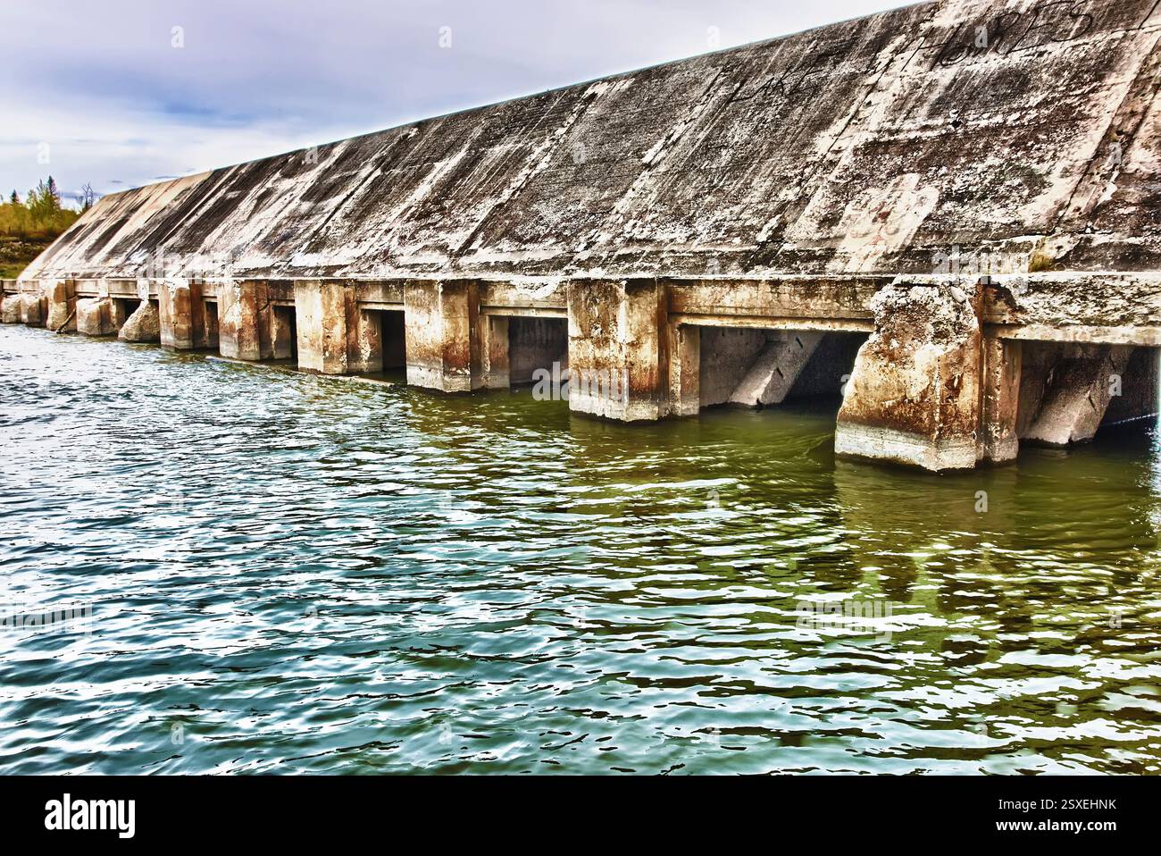 Bridge with a lot of pillars and a lot of water underneath it. The water is green and the bridge ...