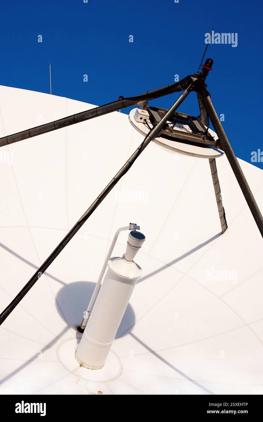 White satellite dish with a black pole on top. The pole is attached to ...