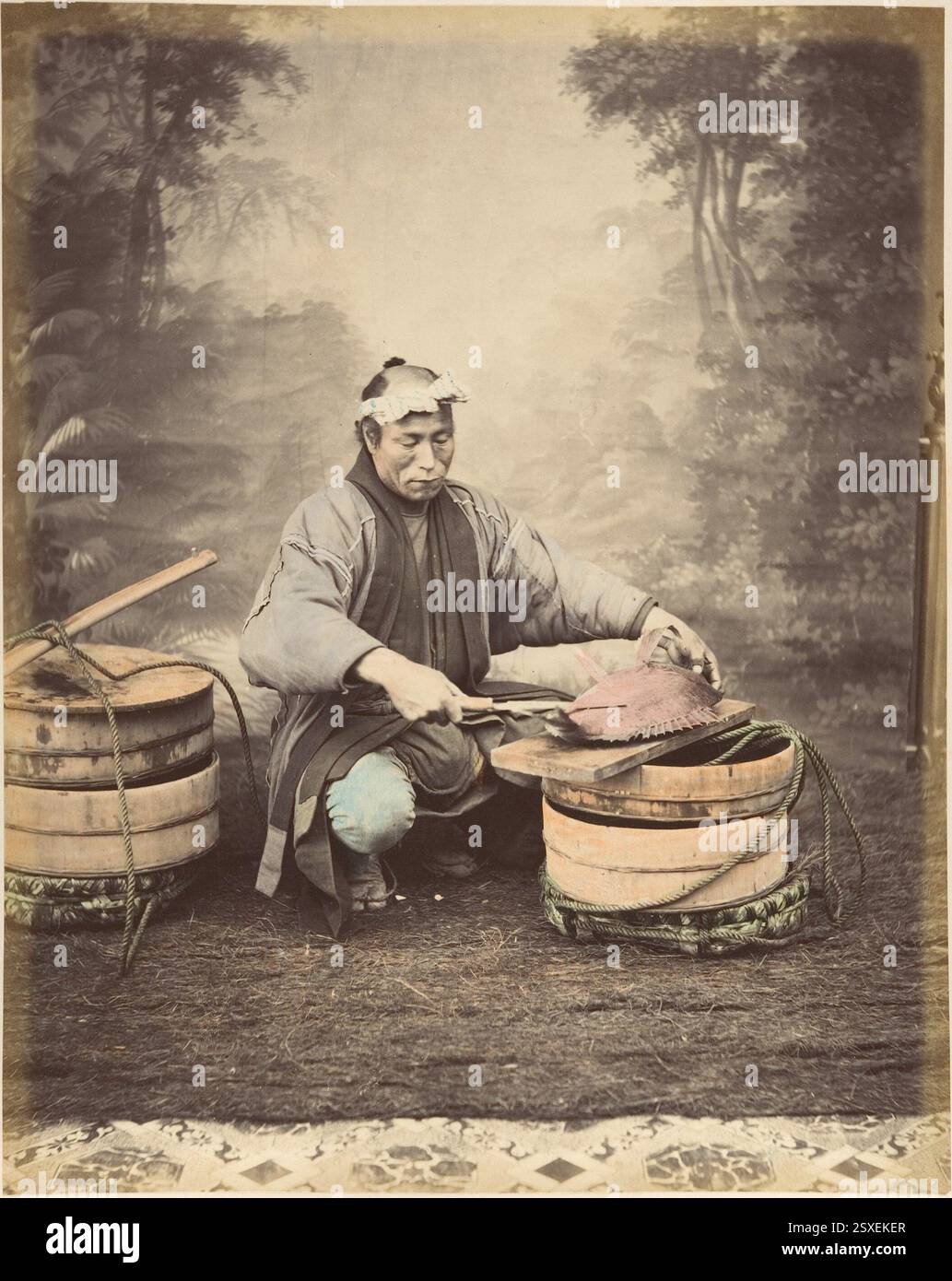 This photograph by Suzuki Shin'ichi from the 1870s shows a Japanese man preparing a fish ...