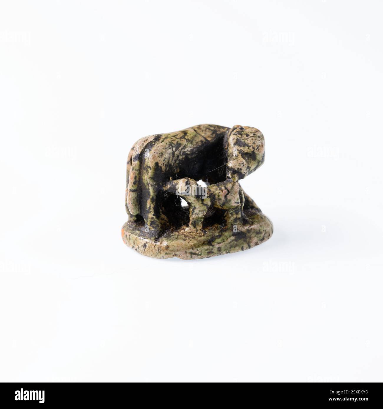 Design amulet depicting a cow nursing a calf, with a kneeling man ...