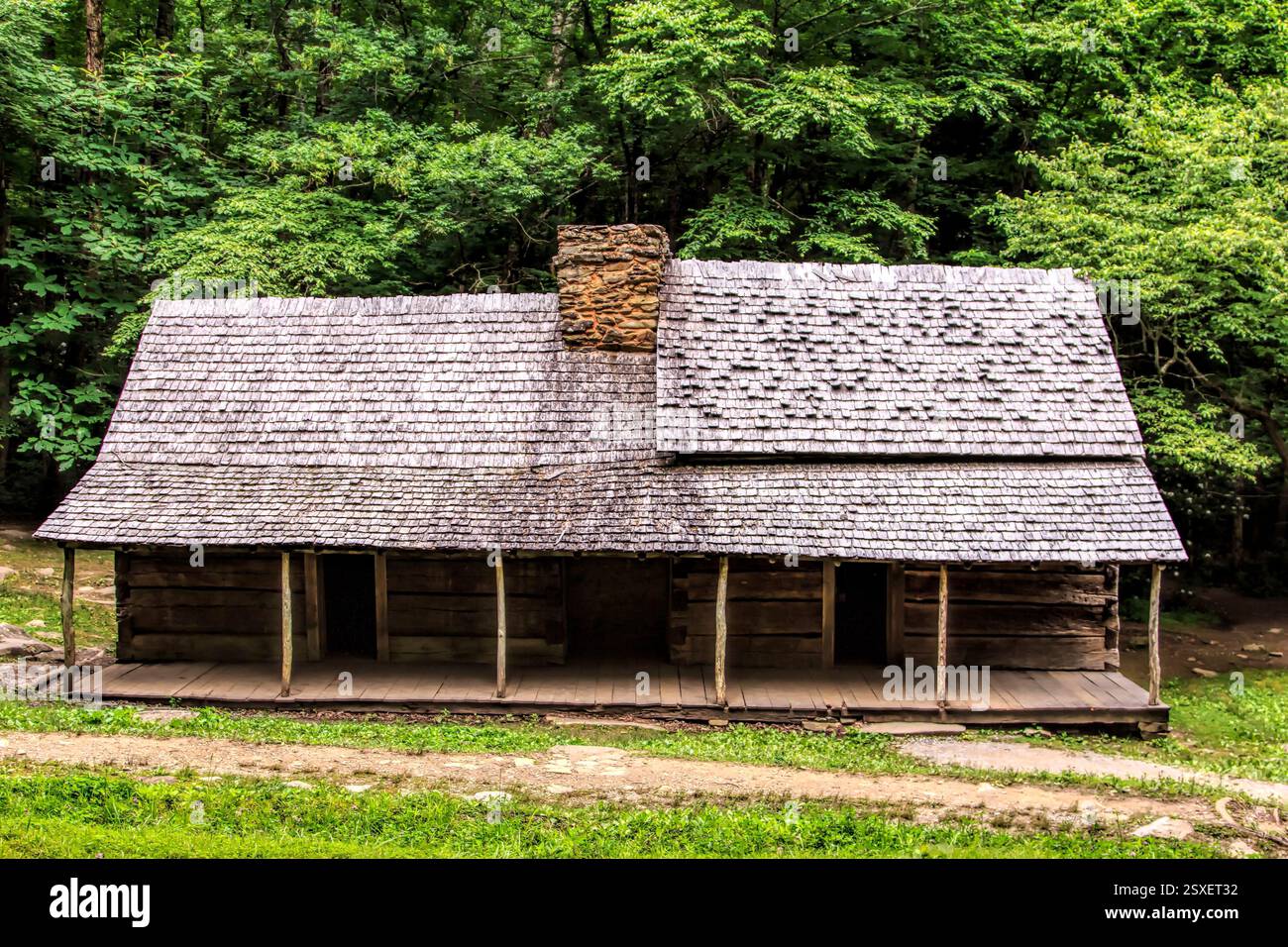 Small house with a chimney and a porch. The house is made of wood and ...