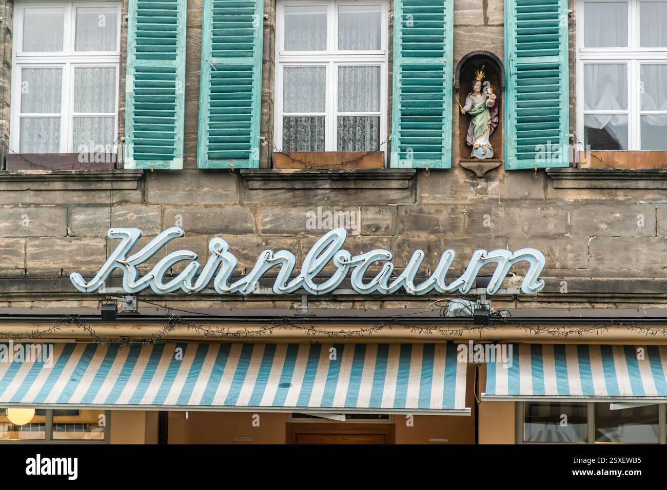 A fish shop in Germany displays a neon sign for "Karbaum" and a statue ...
