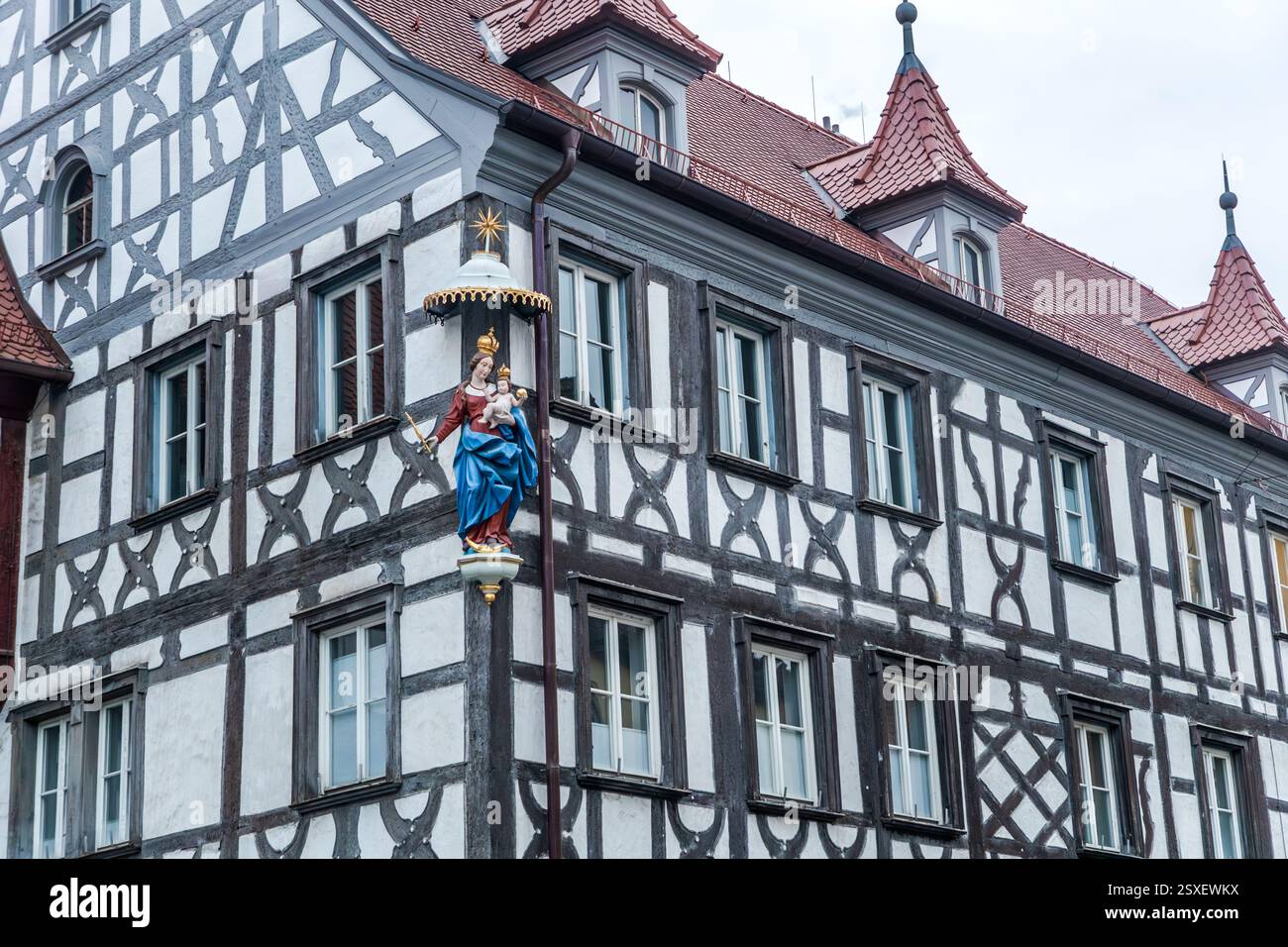 A statue of the Virgin Mary and Child is displayed on a half-timbered ...