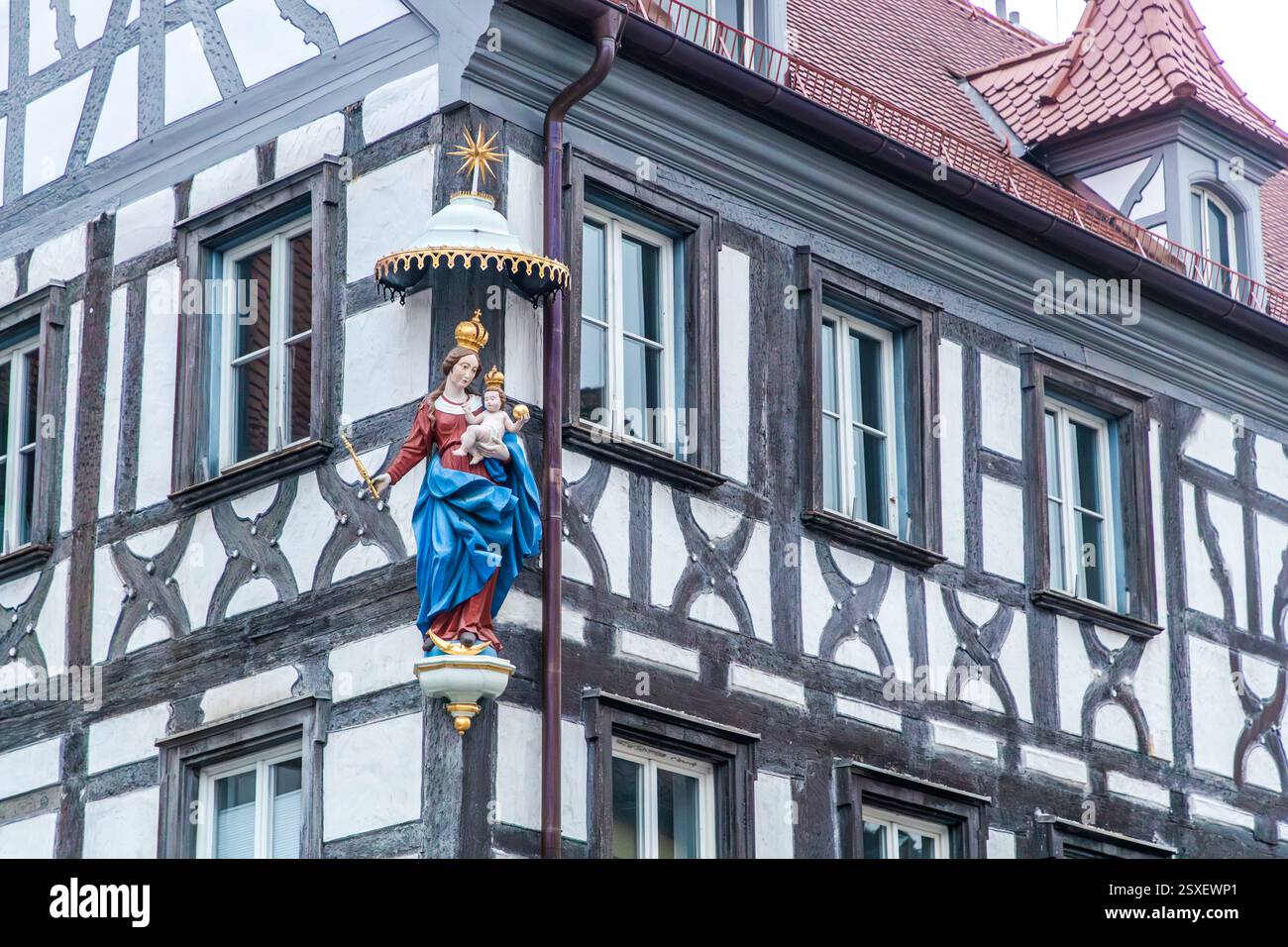 A statue of the Virgin Mary and Child is displayed on a half-timbered ...