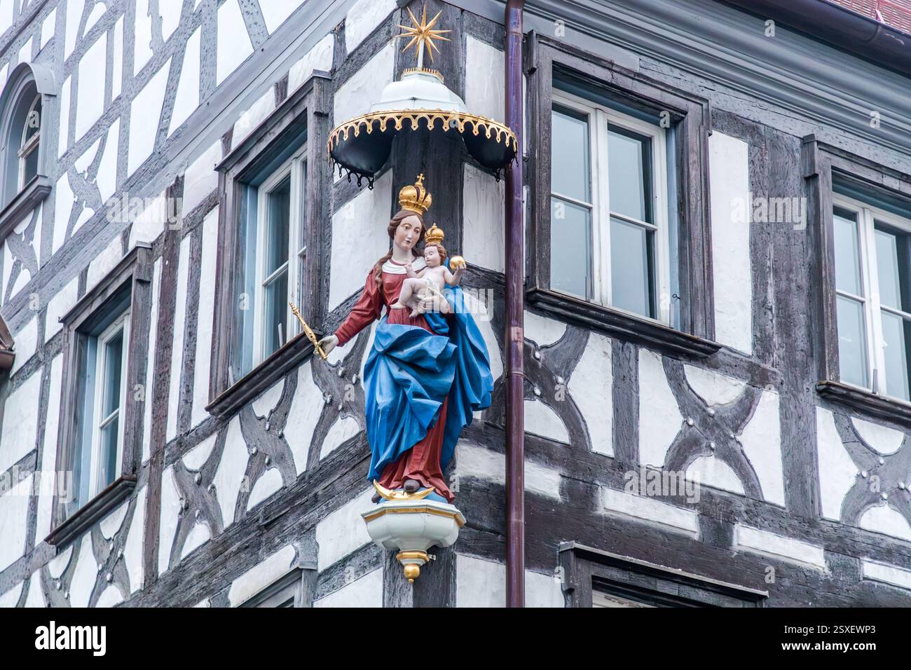 A statue of the Virgin Mary and Child is displayed on a half-timbered ...