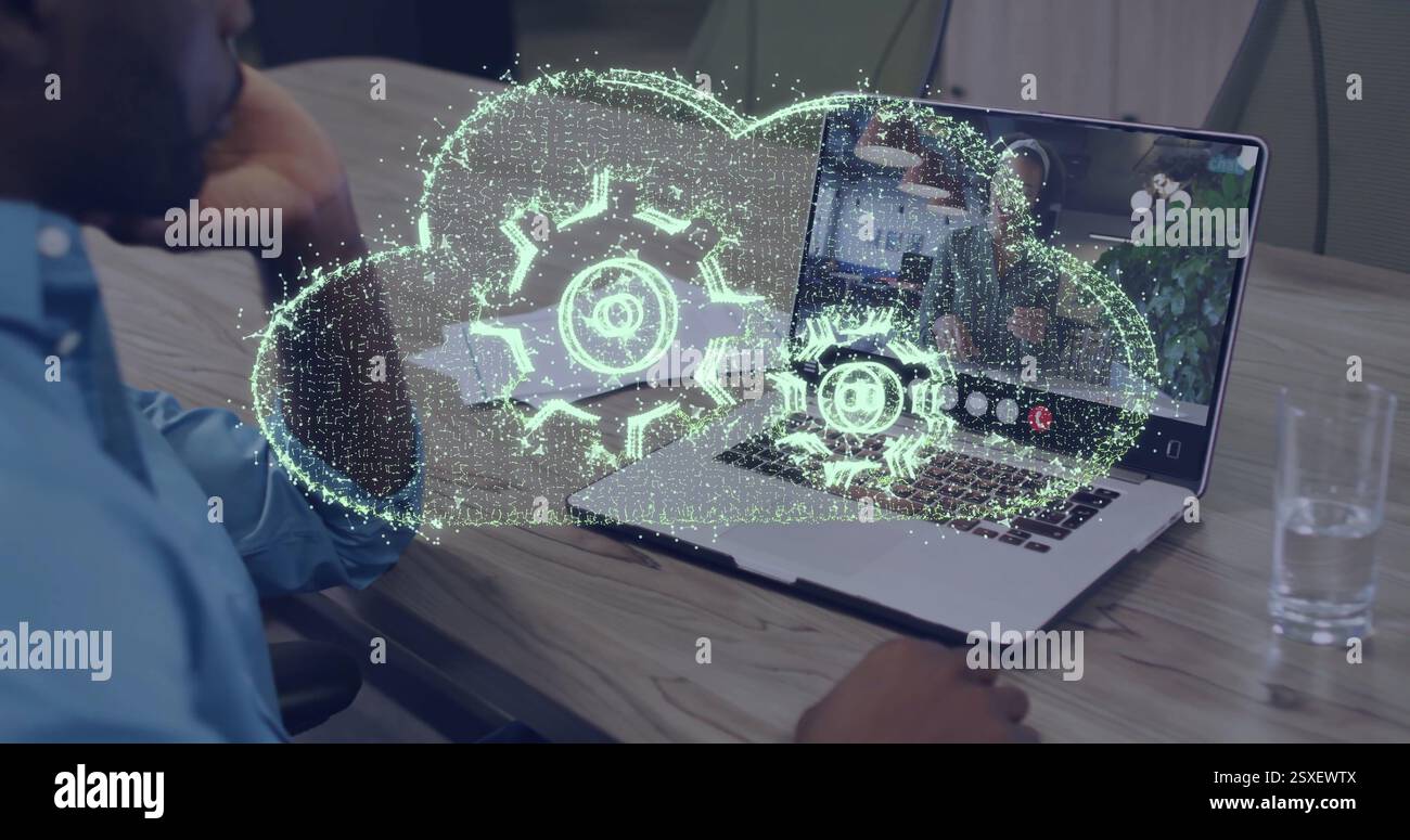 Image of cloud with cogs over african american businessman on laptop ...