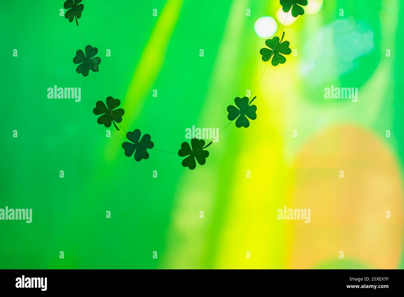 Clover garland hanging in front of blurred green and yellow glowing ...