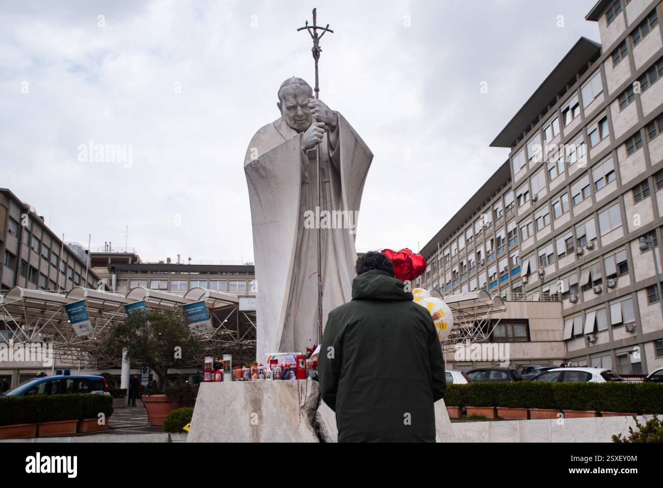 Rome, Italy. 24th Feb, 2025. Faithful pray in front of the statue of ...