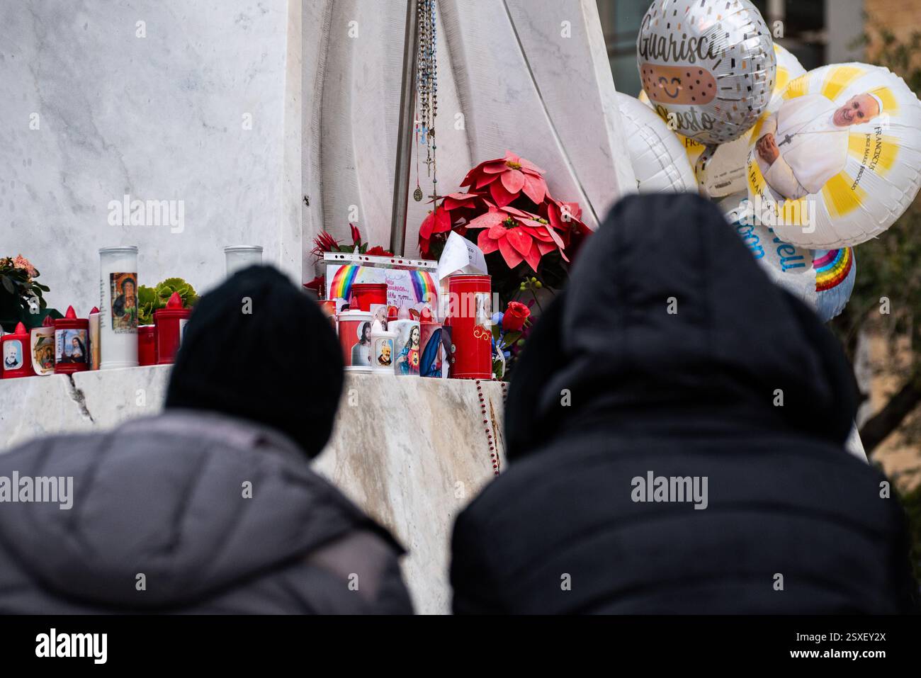 Rome, Italy. 24th Feb, 2025. Faithful pray in front of the statue of ...